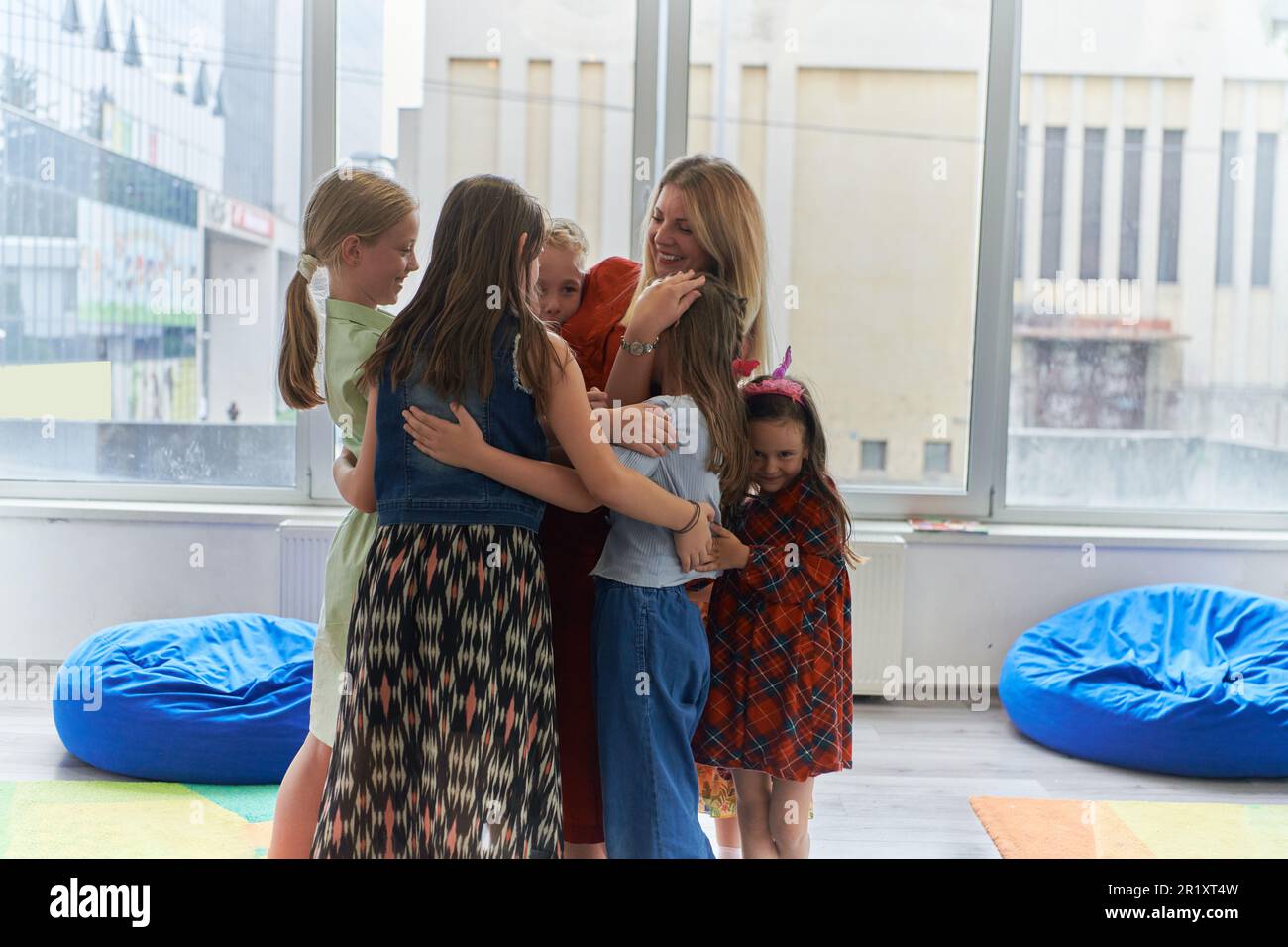 A child hugging a teacher in a modern kindergarten Stock Photo - Alamy