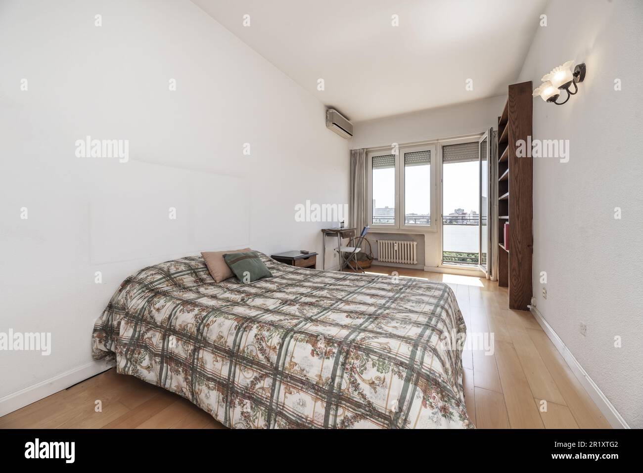 Long room with double bed with access to a terrace through a glass door ...