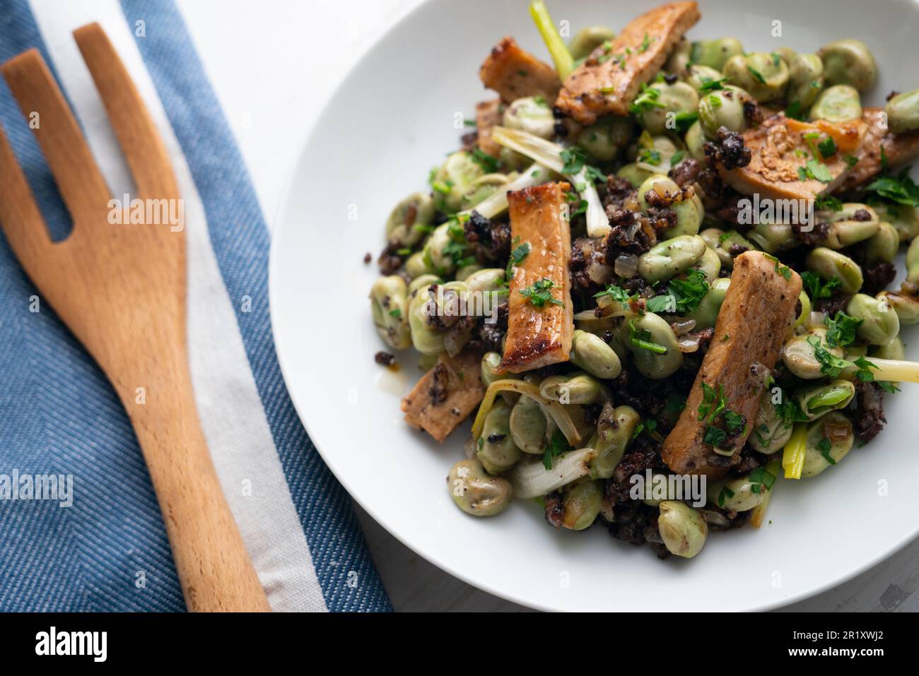 Sautéed pork loin with green beans and black pudding Stock Photo - Alamy