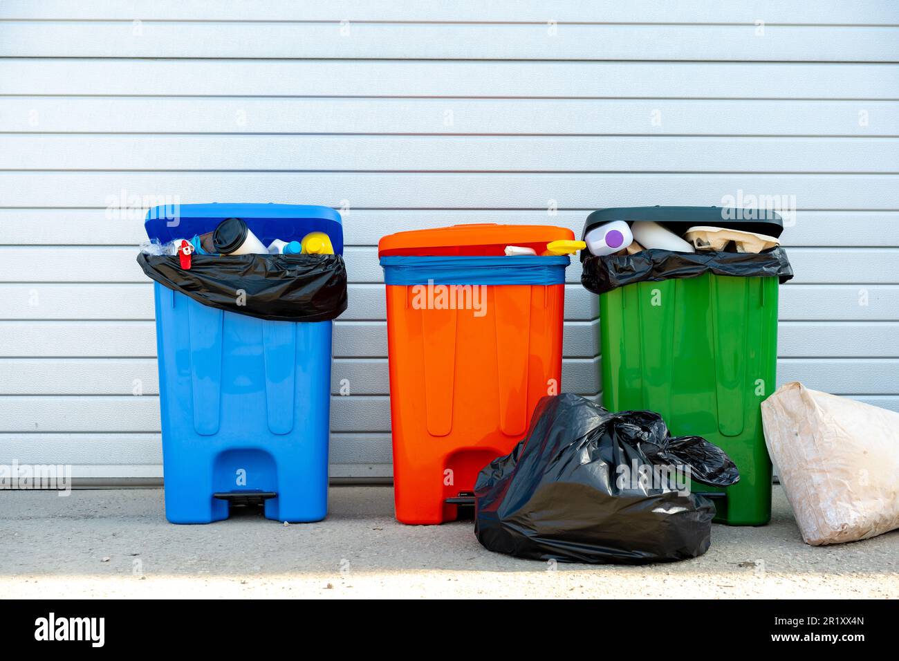 Three trash containers full of garbage near the building Stock Photo ...