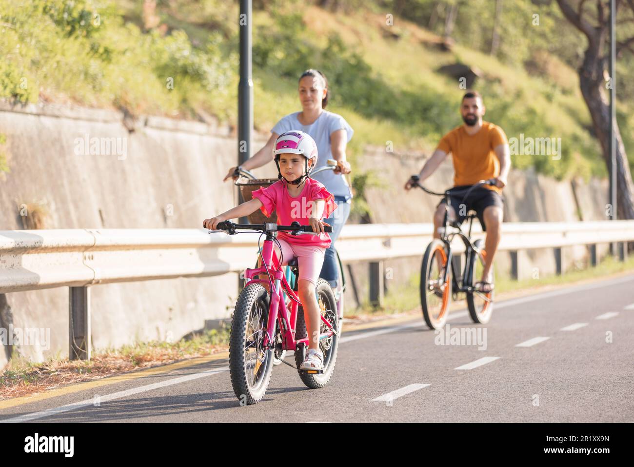 Mother, father and girl child having fun on vacation cycling near the ...