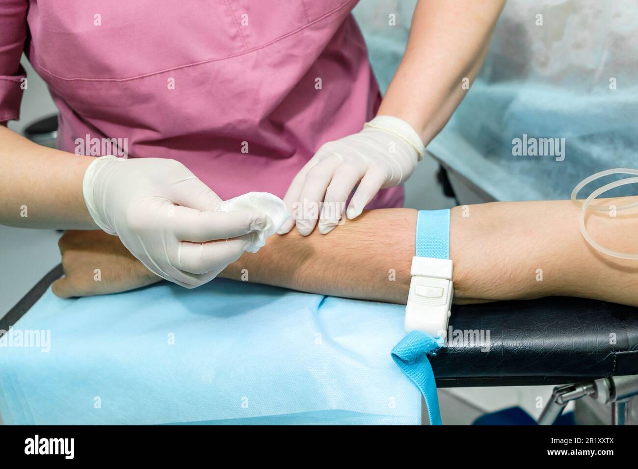 The doctor disinfects the patient's hand with an alcohol solution ...
