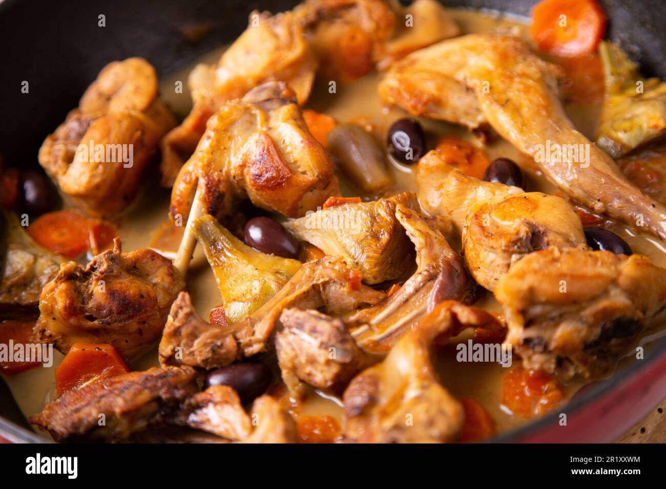 Fried rabbit cooked with lemon sauce, artichokes and vegetables Stock ...