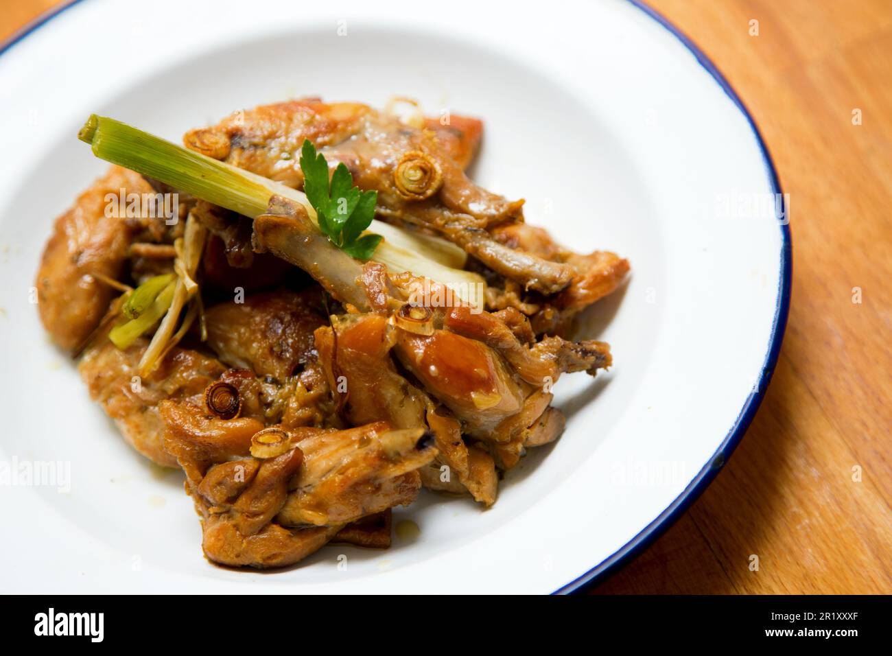 Fried rabbit cooked with lemon sauce and young garlic Stock Photo - Alamy