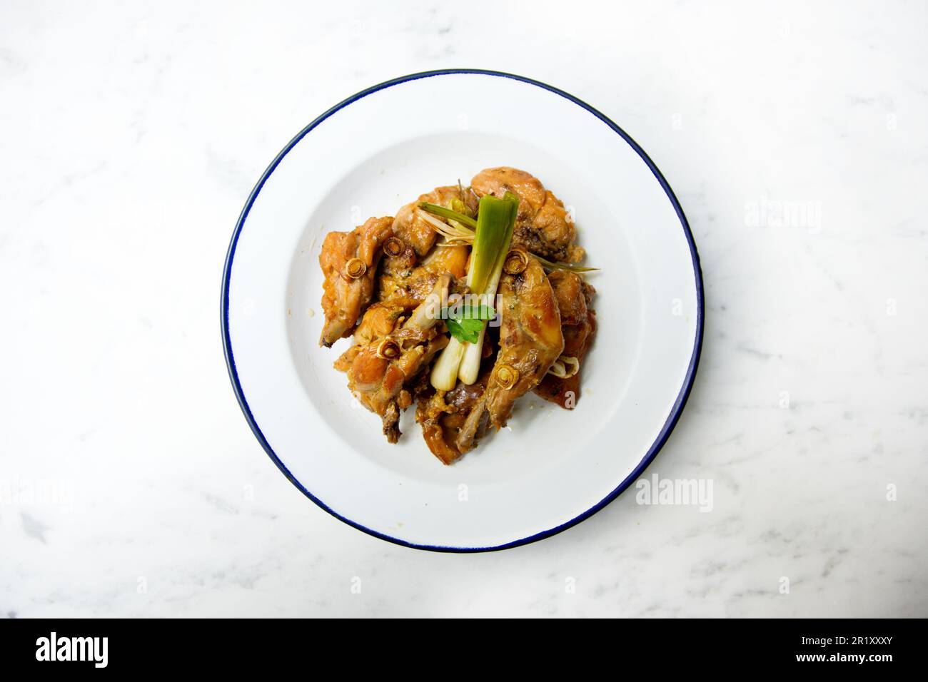 Fried rabbit cooked with lemon sauce and young garlic Stock Photo - Alamy