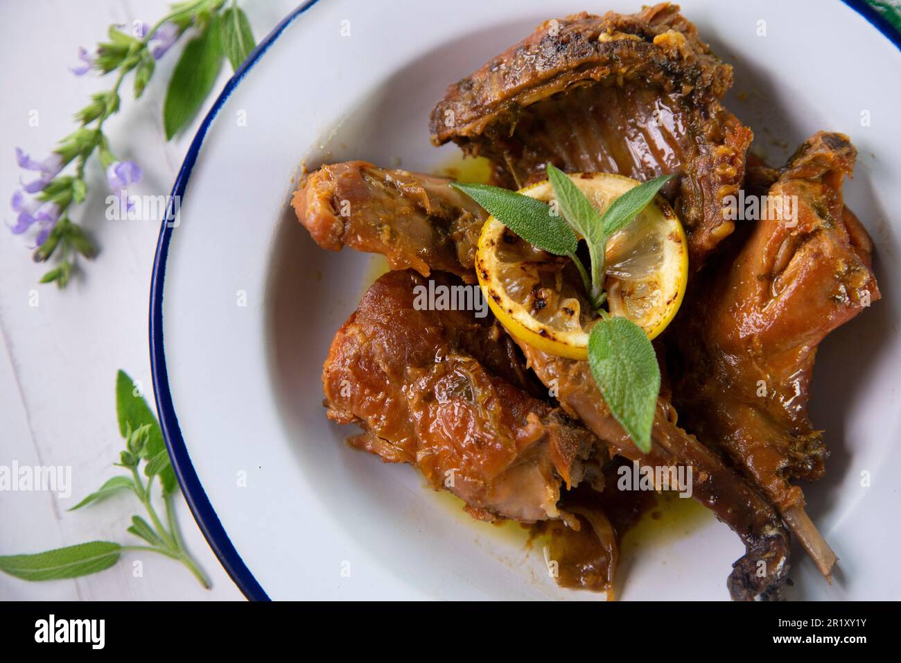 Fried rabbit cooked with lemon and sage sauce Stock Photo - Alamy