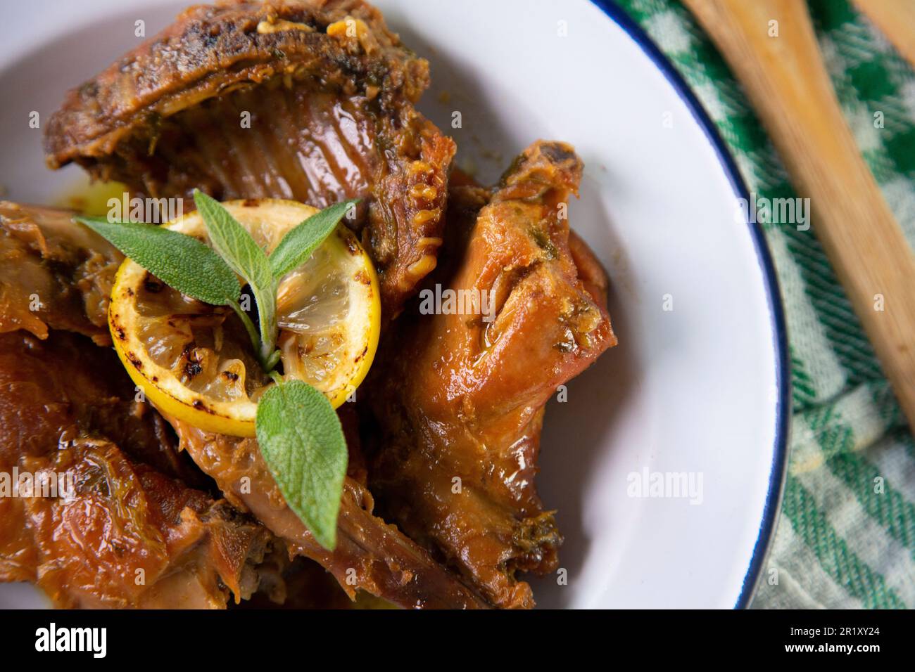 Fried rabbit cooked with lemon and sage sauce Stock Photo - Alamy