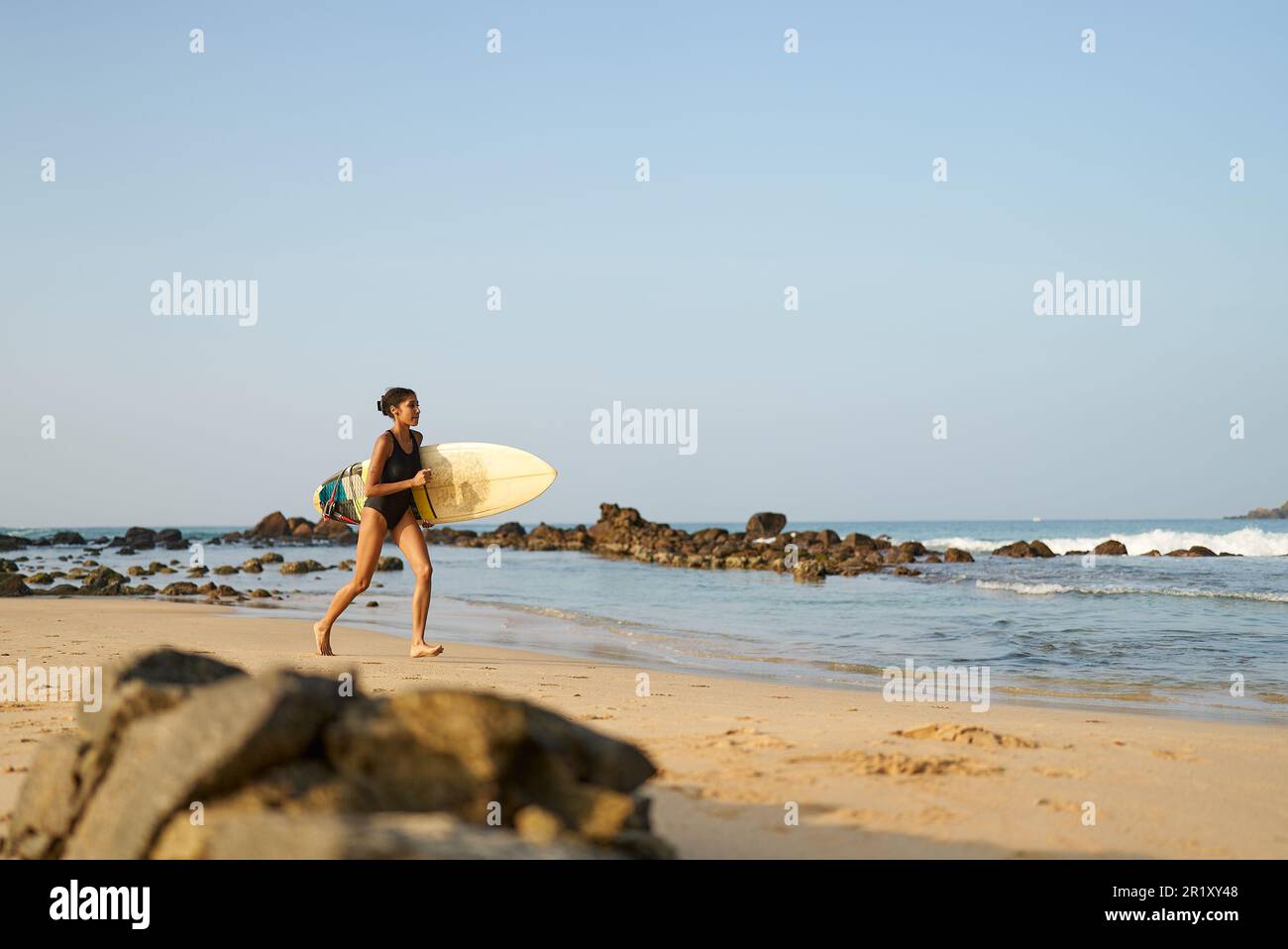 African american woman running with surfboard on ocean beach. Black ...