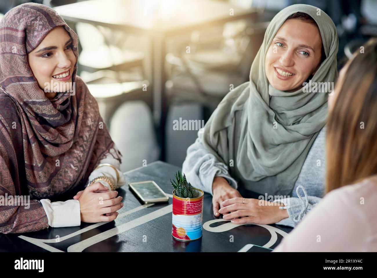 Friends, relax and Muslim women in coffee shop, bonding and talking ...