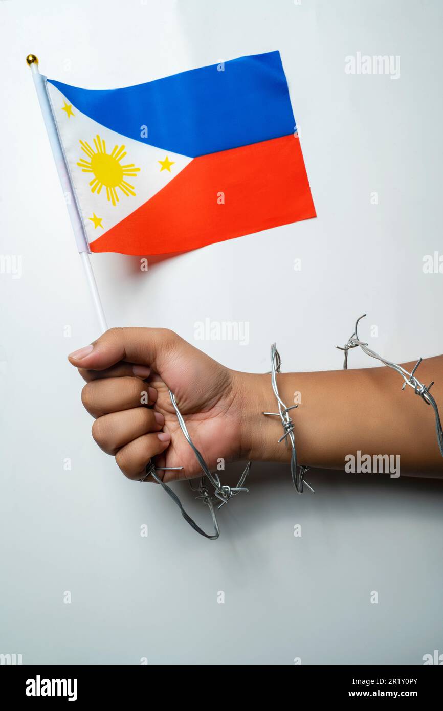 Human hand tied barbed wire with the Philippines national flag on white ...