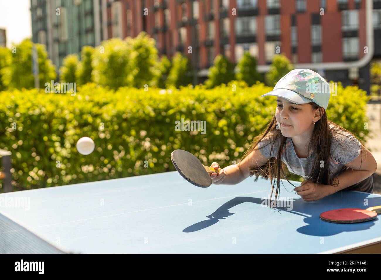 Little girl playing ping pong in park Stock Photo - Alamy