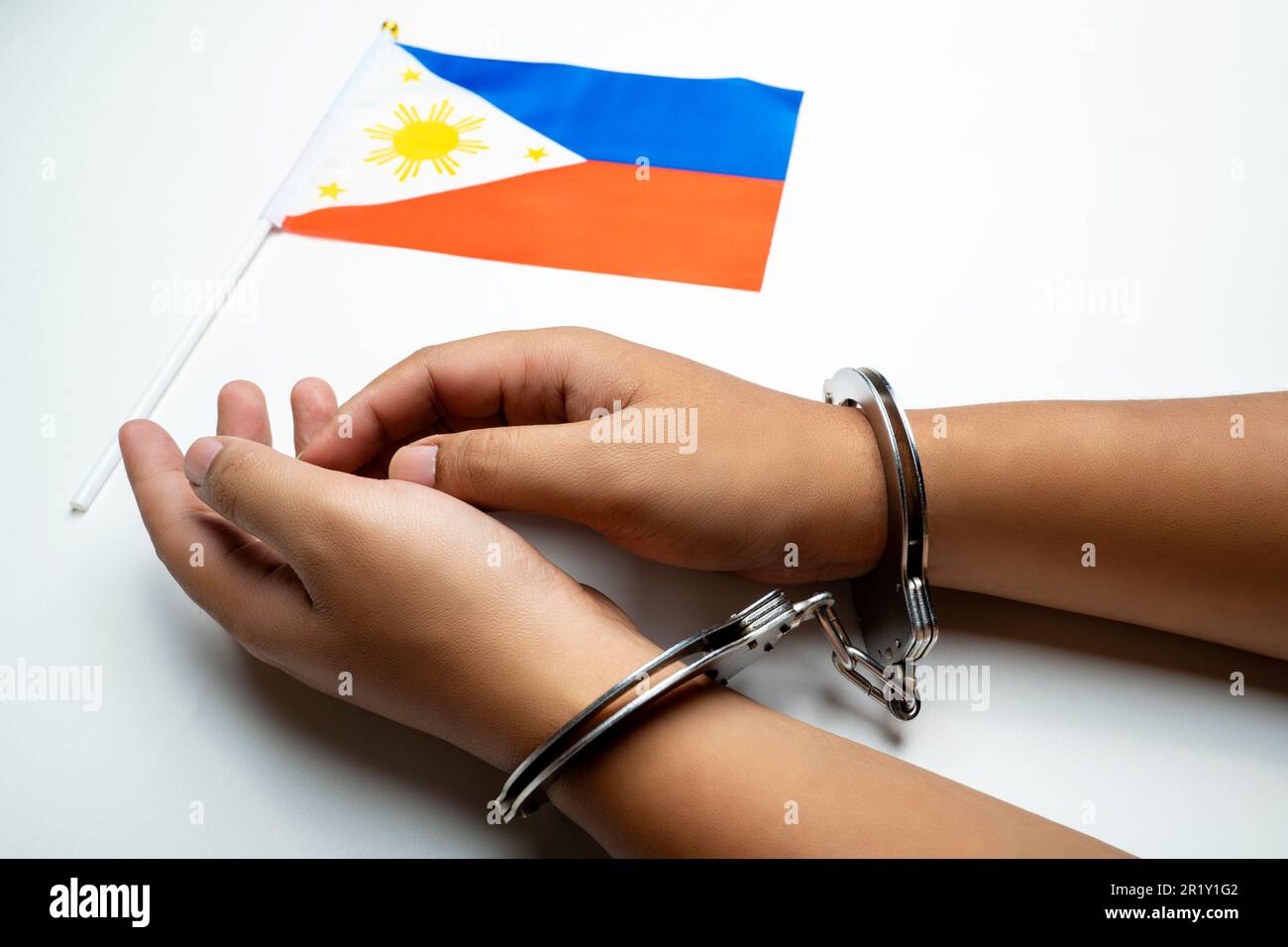 Human hand in handcuff with Philippines national flag on white ...
