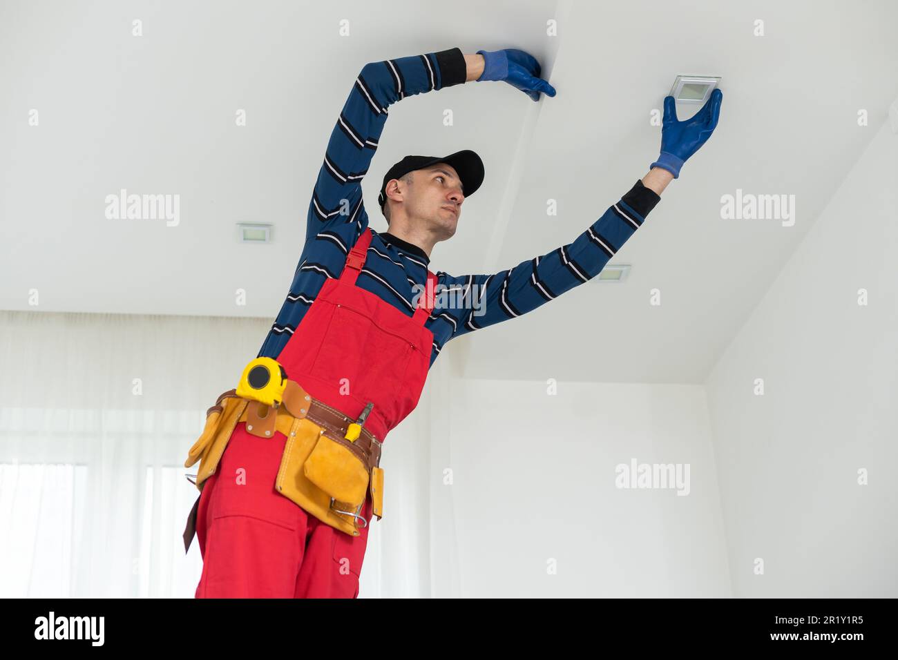 man plasterer construction worker at work, takes plaster from bucket ...