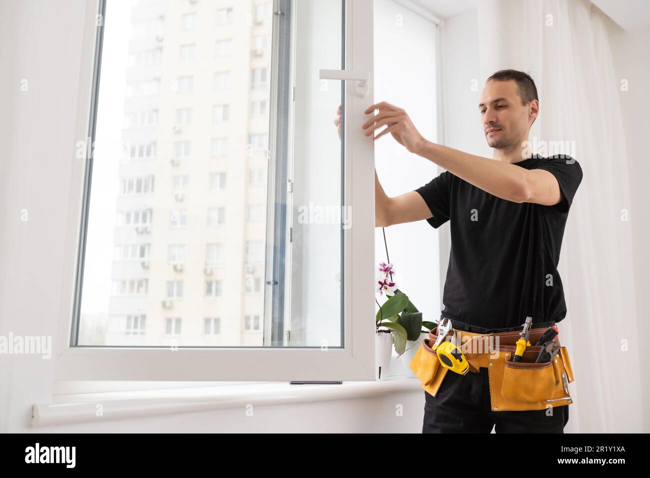Worker adjusting installed window with screwdriver indoors, closeup ...
