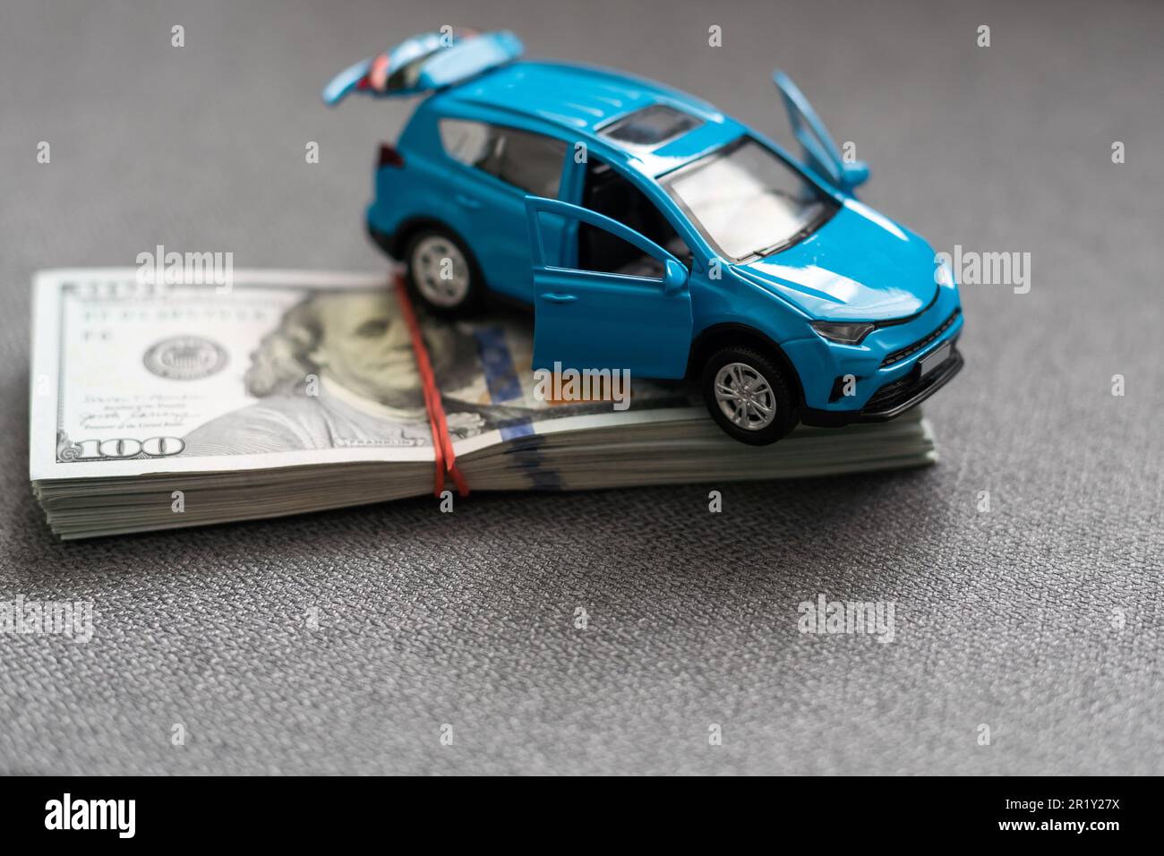 Money to buy or rent a car concept. Toy car with money cash Stock Photo ...