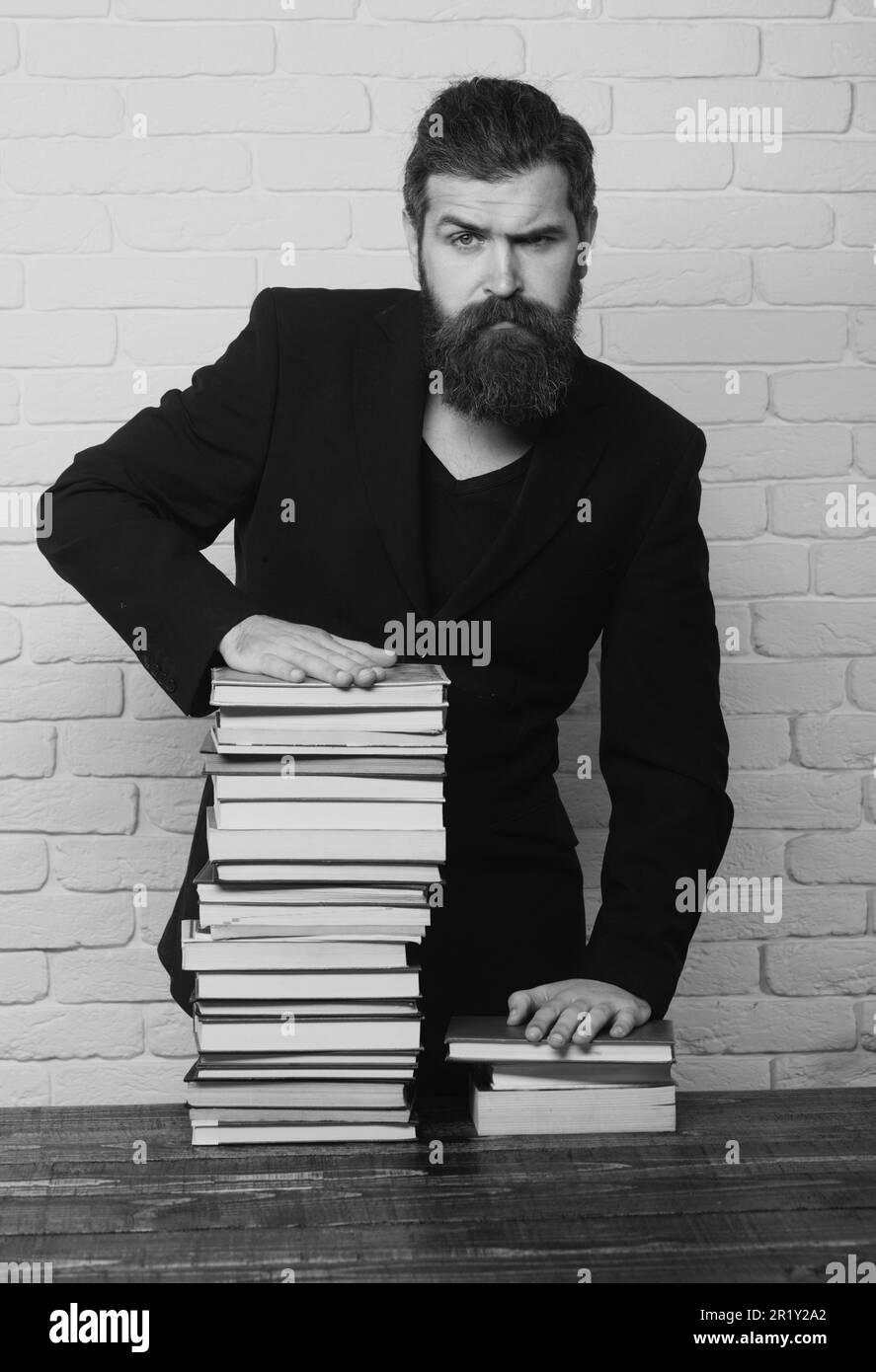 Serious teacher or professor with book stack. Thinking serious mature ...