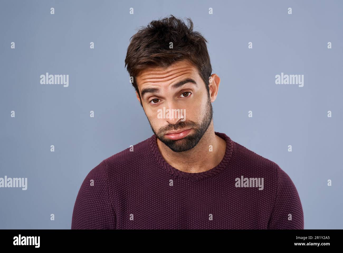 Bored, portrait and annoyed man in studio tired and moody against a ...