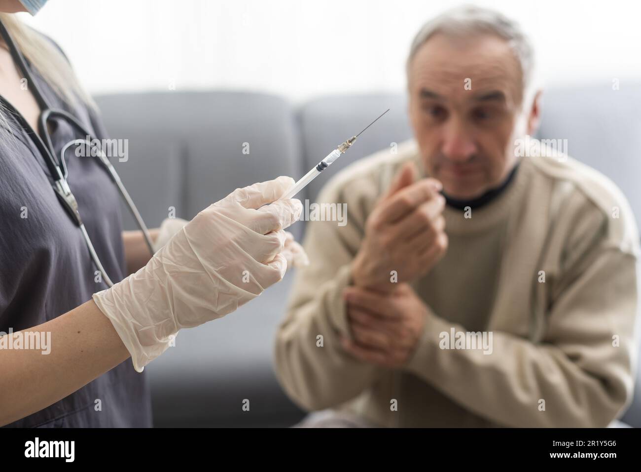 Doctor giving vaccination shot to elderly patient by syringe or ...