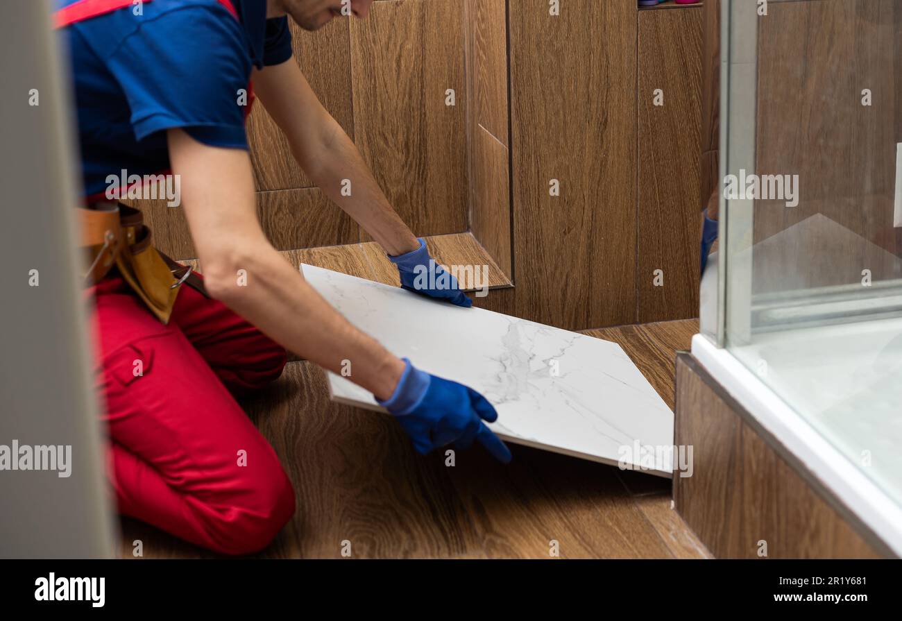 Home improvement, renovation - construction worker tiler is tiling ...