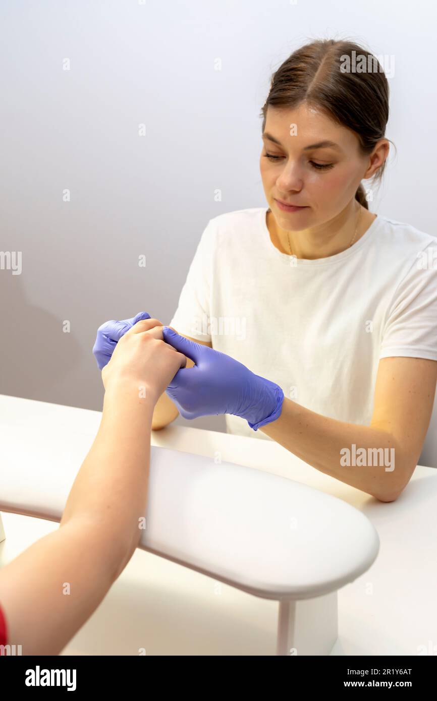 Nail professional examines, checks up child's fingernails at ...