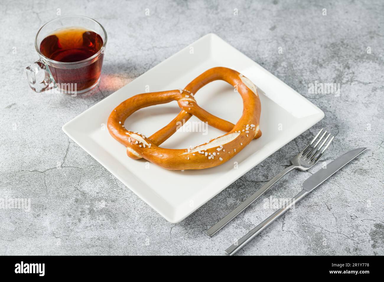 Pretzel in white porcelain plate on stone background Stock Photo - Alamy
