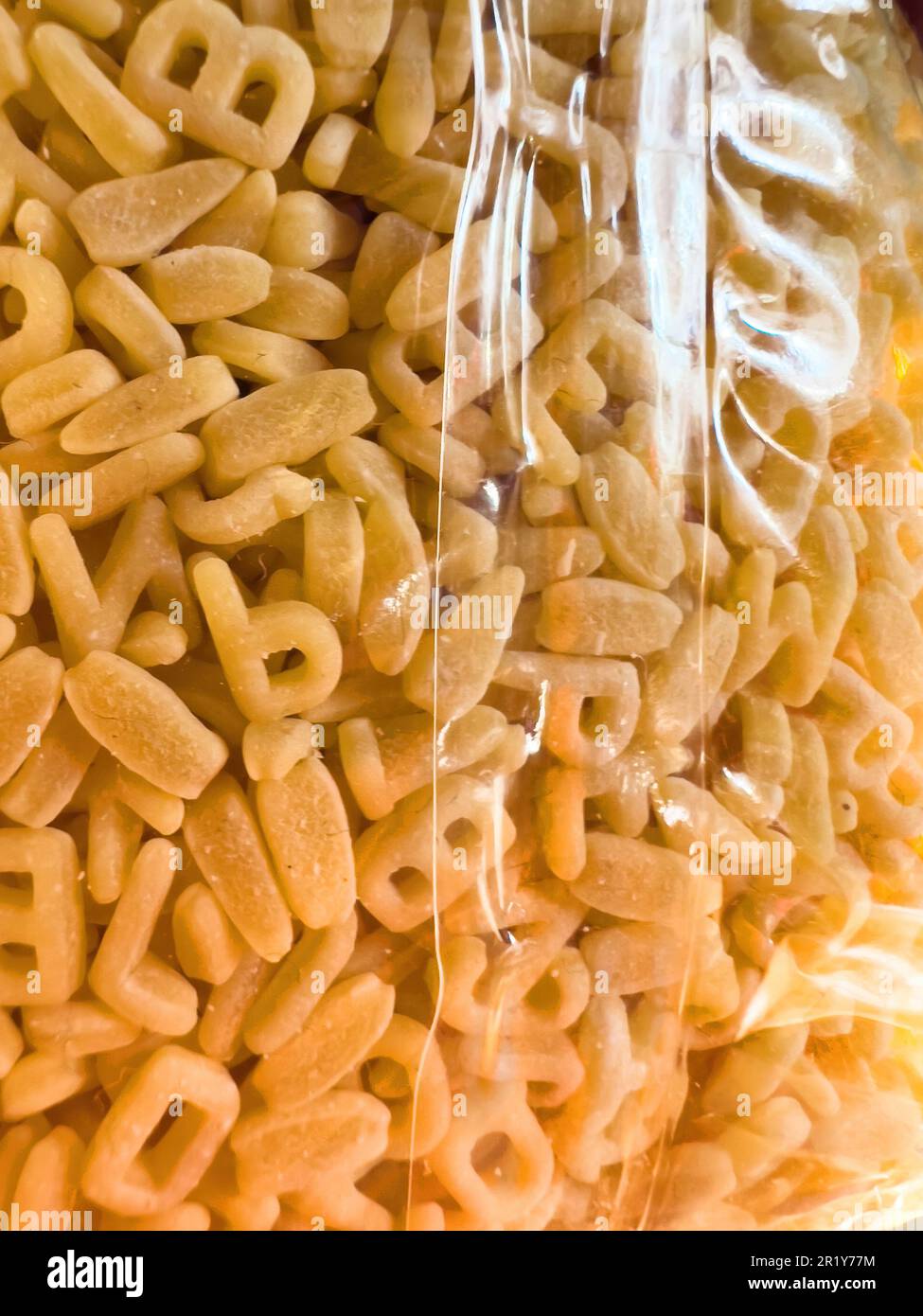 A bowl of bright yellow alphabet pasta letters, a perfect addition to ...