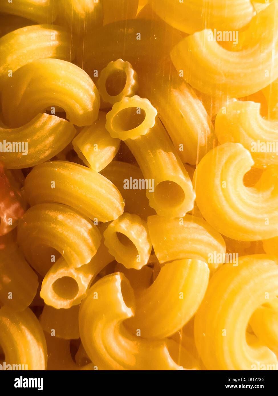 A large group of uncooked yellow pasta laid out, ready to be cooked and ...
