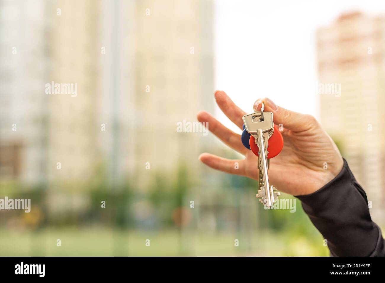 Hand holding keys in front of building Stock Photo - Alamy