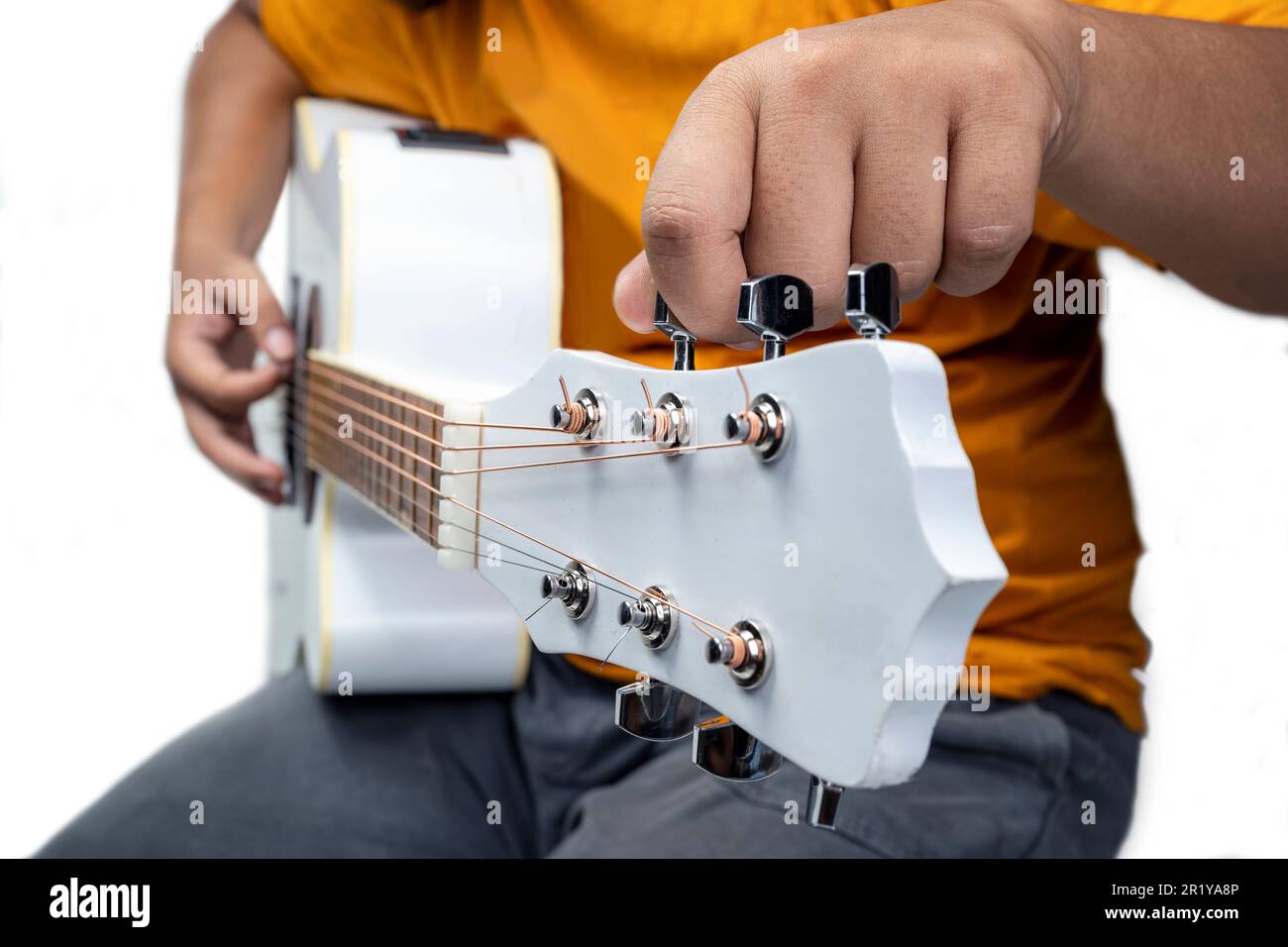 Man tuning guitar string isolated over white background Stock Photo - Alamy