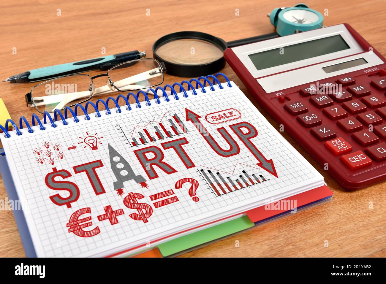 start up diagram in notebook and red calculator Stock Photo - Alamy