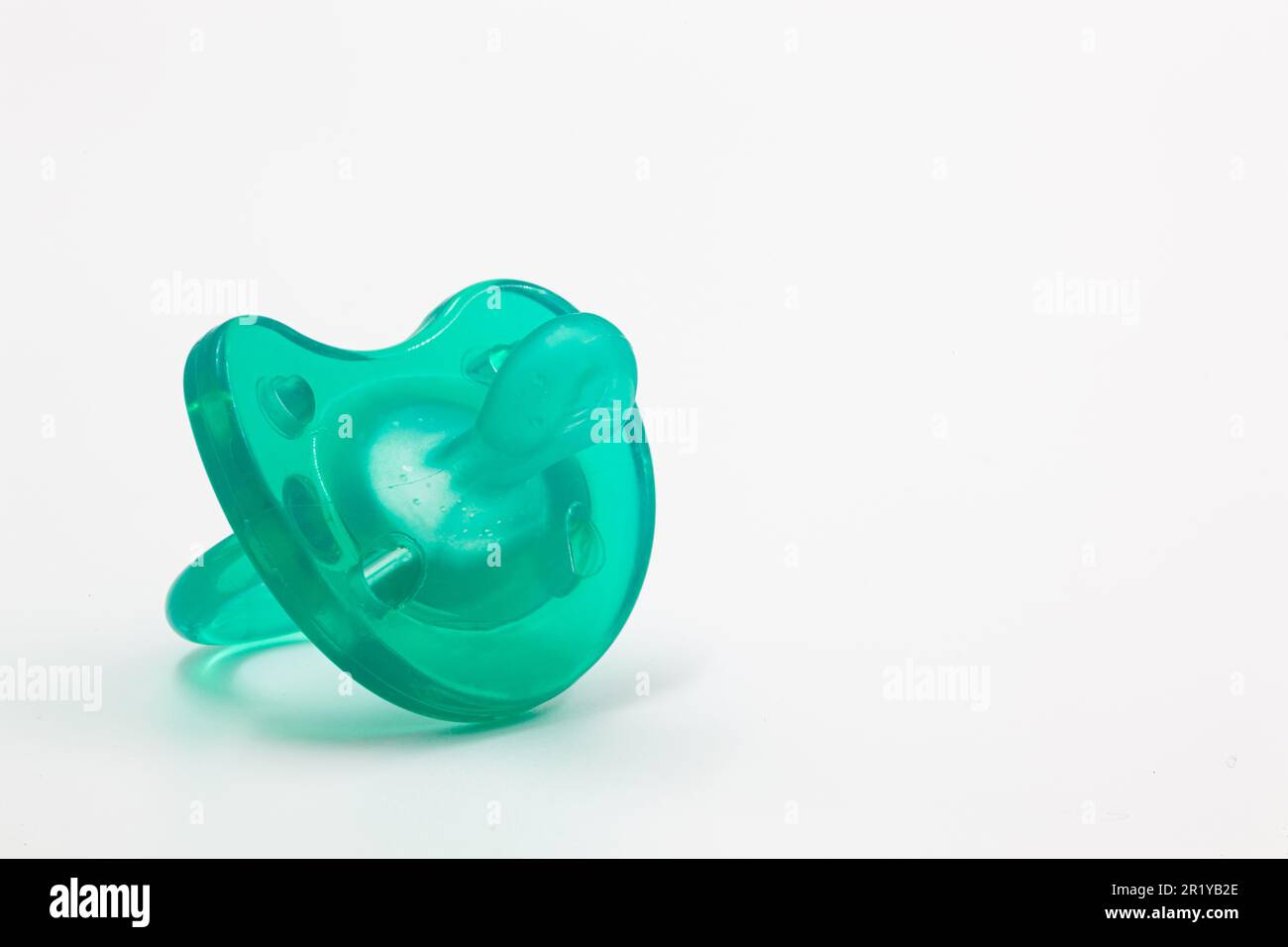 Turquoise pacifier for a newborn on a white insulated background ...