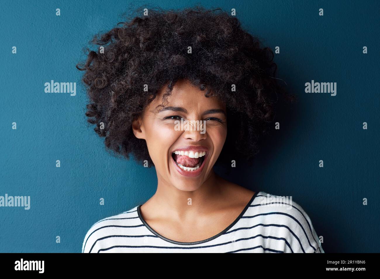 Portrait, funny and woman with tongue out, silly and happiness against ...