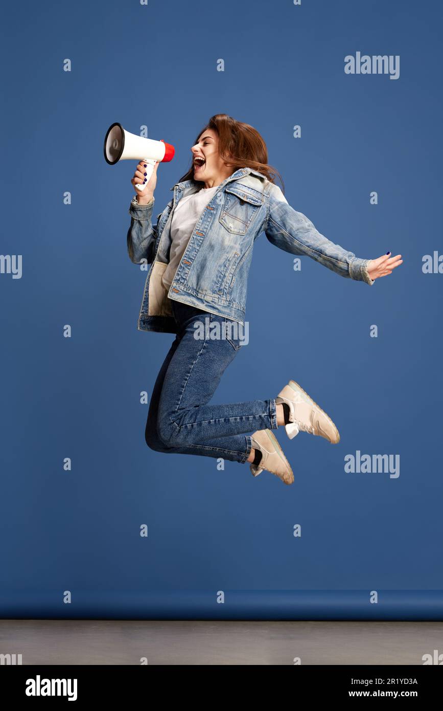 Portrait with one joyful, smiling young girl, student jumping and ...
