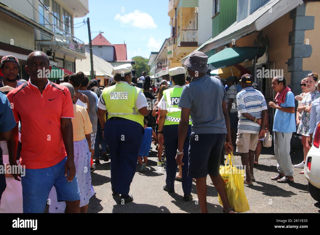 Busy scene on the street in the front of a small shop in town center ...