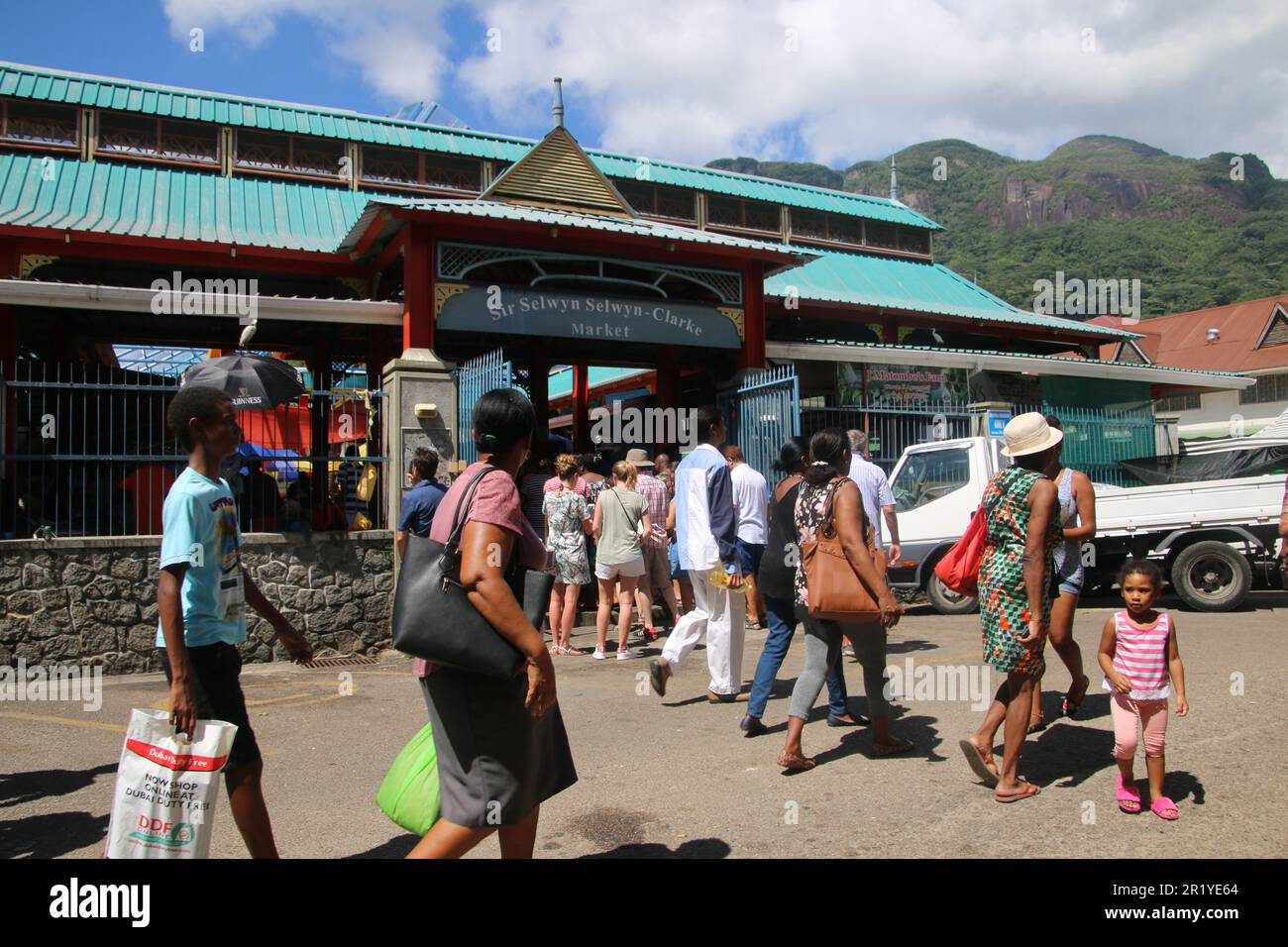 Busy scene on the street in the front of a small shop in town center ...