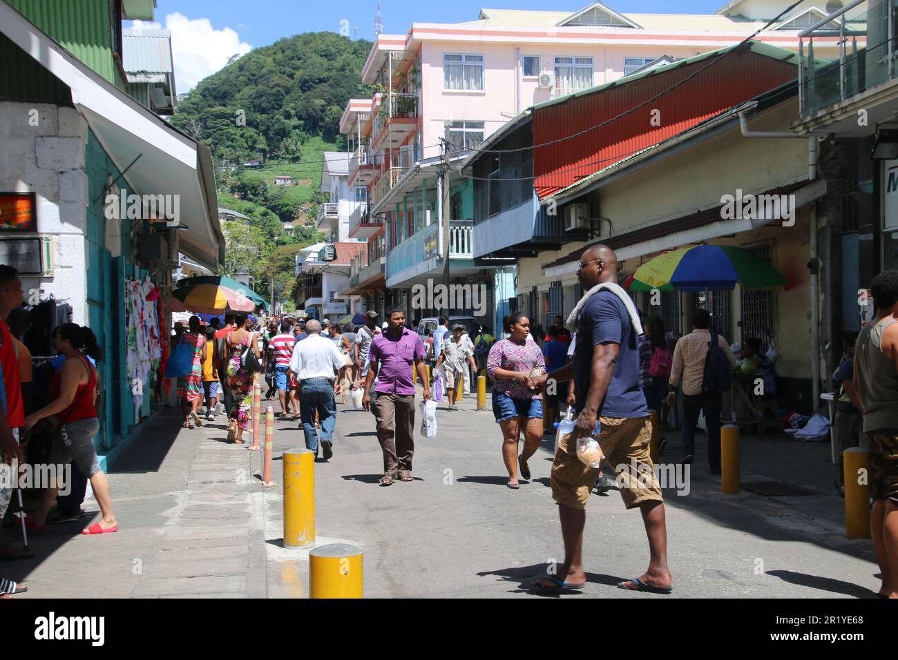 Busy scene on the street in the front of a small shop in town center ...