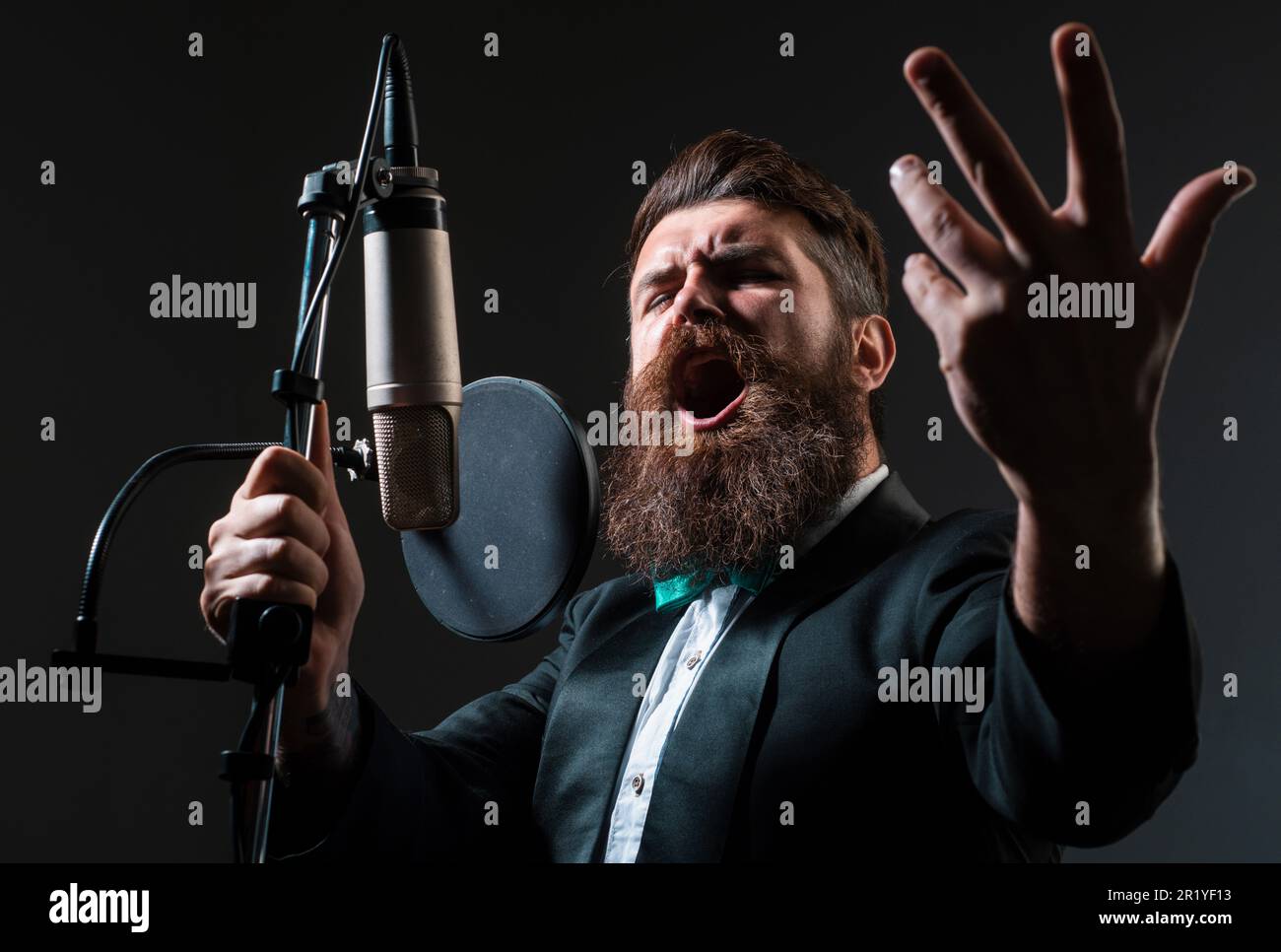 Classic singer in suit. Singer is performing a song with a microphone ...