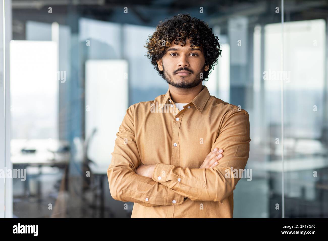 Portrait of a successful young hispanic programmer standing in a modern ...