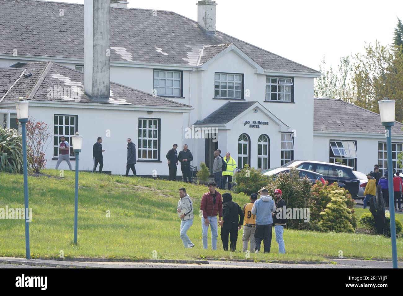 Asylum seekers outside the accommodation at the Magowna House hotel in ...