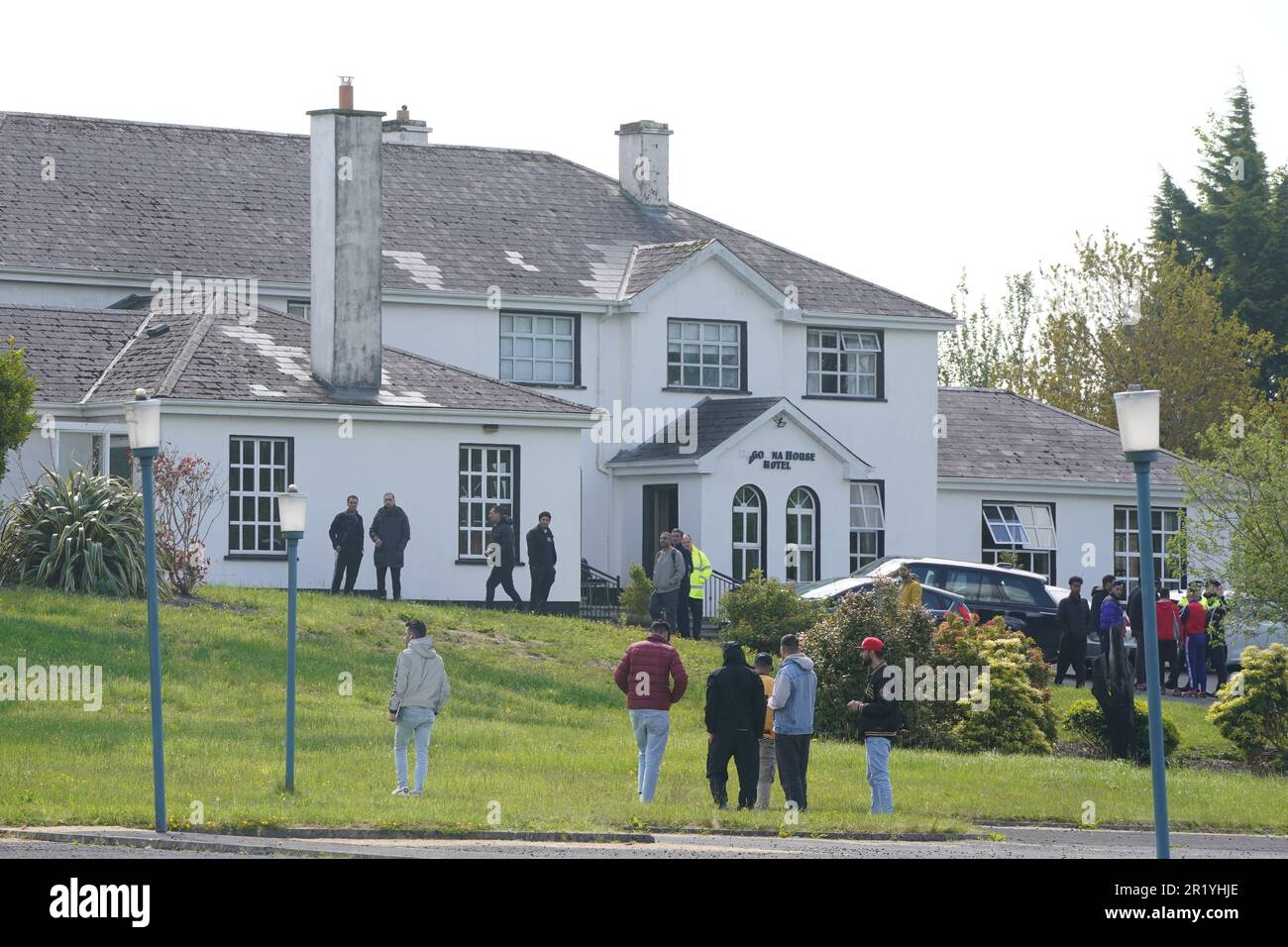 Asylum seekers outside the accommodation at the Magowna House hotel in ...