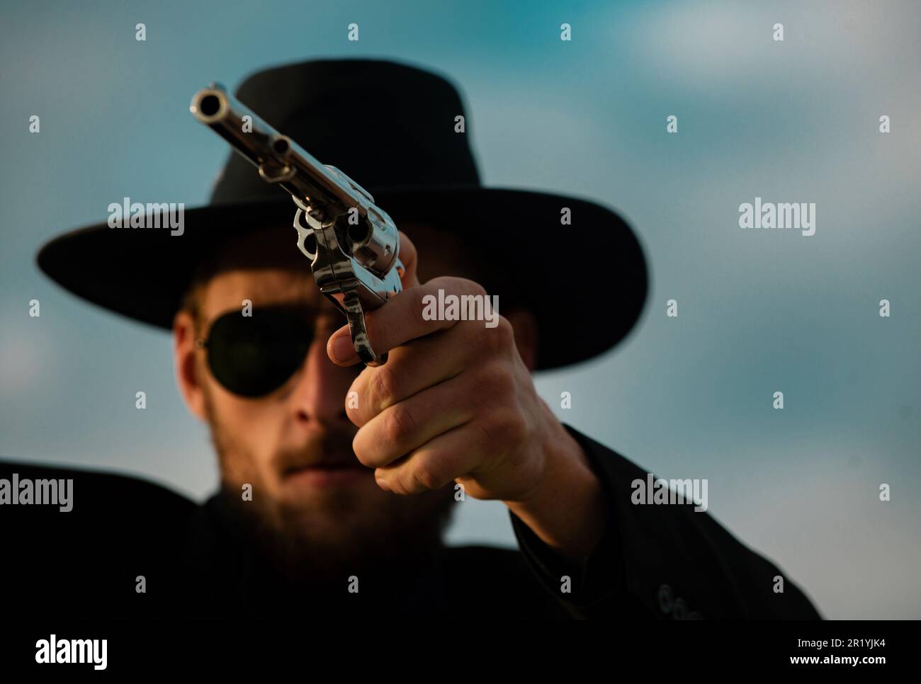 Cowboy shooter in black suit and cowboy hat. Serious man with wild west ...