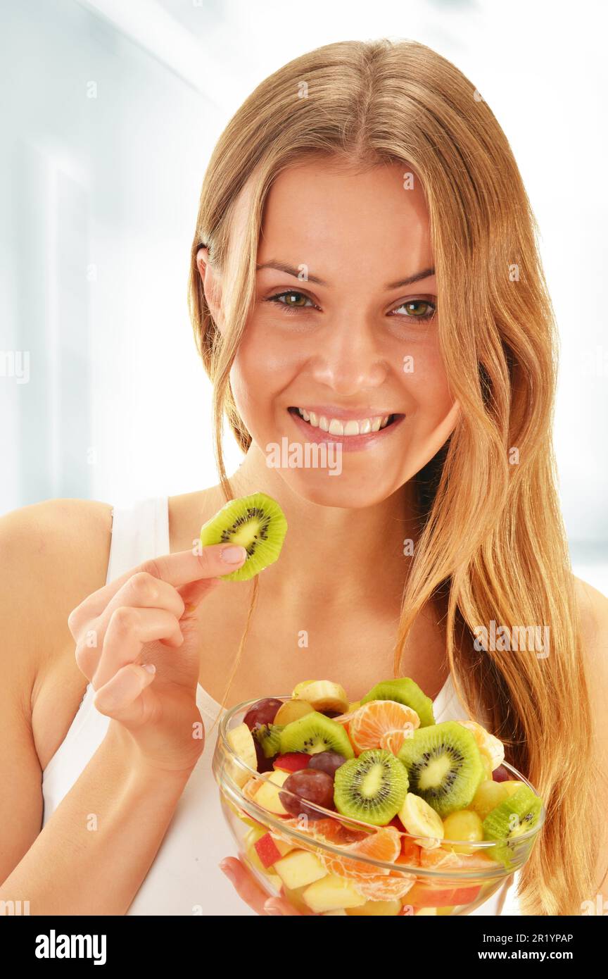 Young woman eating fruit salad Stock Photo - Alamy