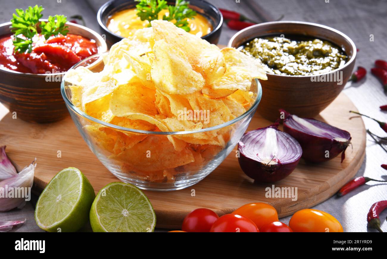 Composition with glass bowl of potato chips and dipping sauces Stock ...