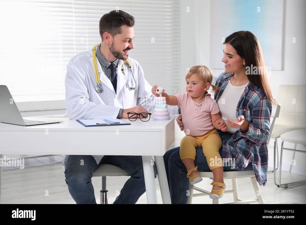 Mother and her cute baby having appointment with pediatrician in clinic ...