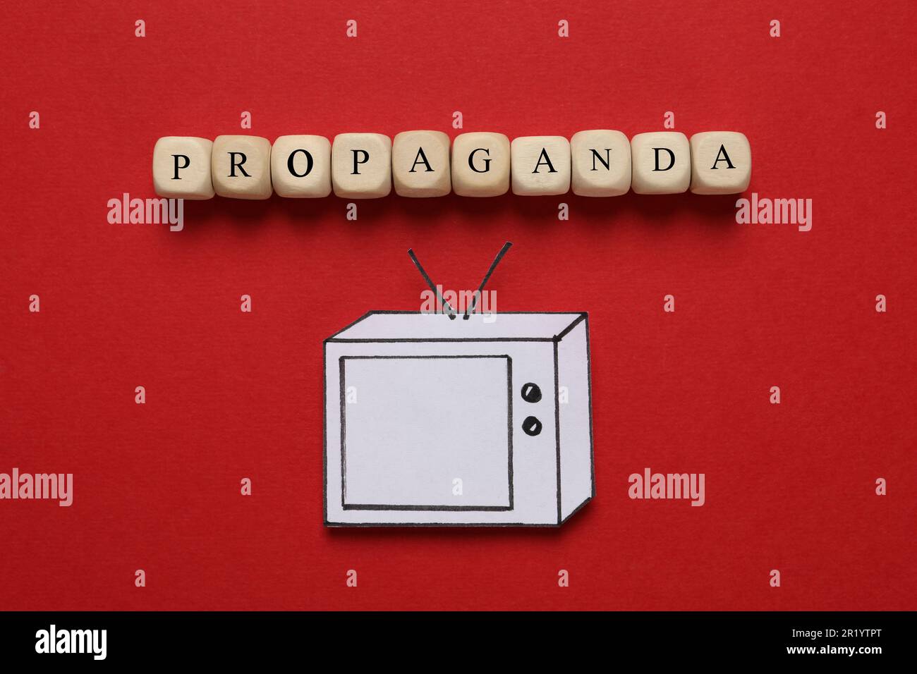 Word Propaganda made of wooden cubes and paper TV on red background ...