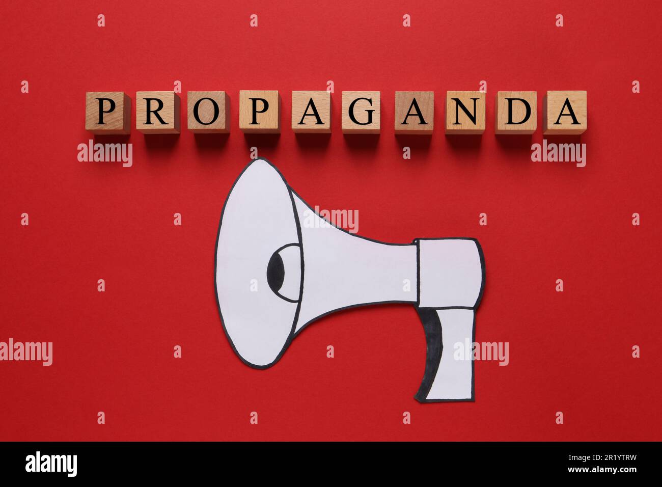 Word Propaganda made of wooden cubes and paper loudspeaker on red ...