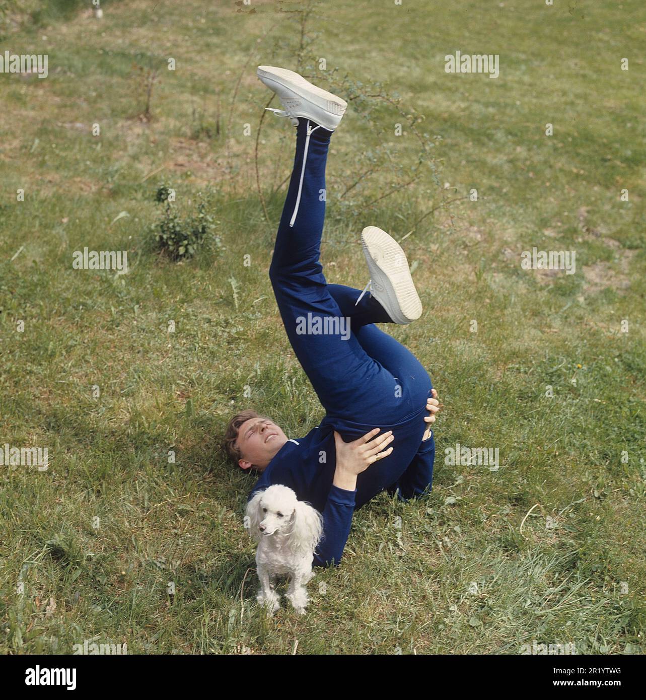 1960s lifestyle. A man is exercising on the lawn, balancing on his ...