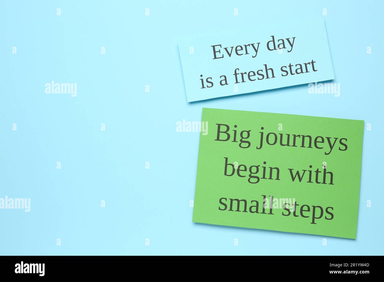 Notes with motivational quotes on light blue background, flat lay ...