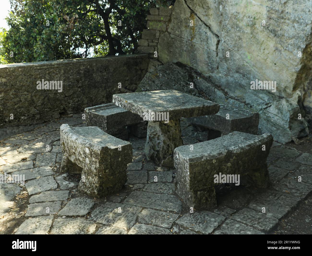Stone table and benches near rock outdoors Stock Photo - Alamy