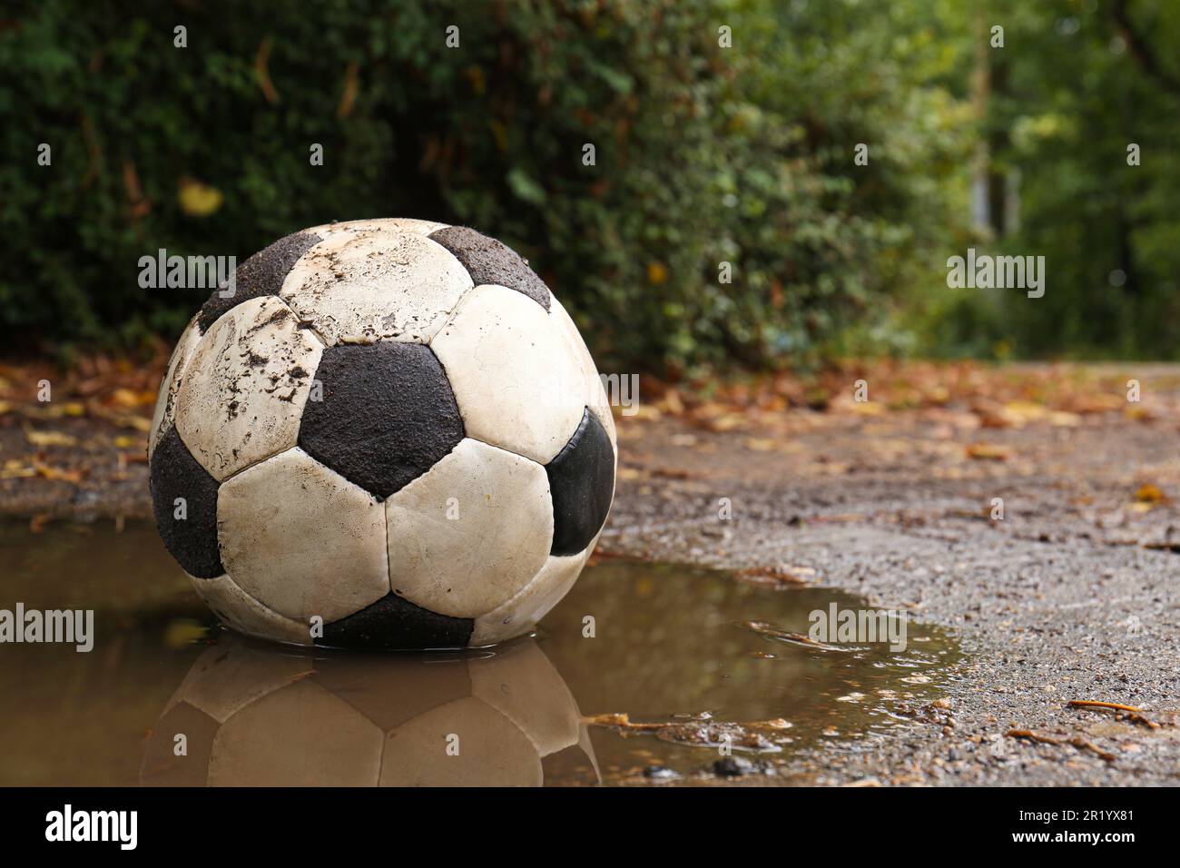 Dirty soccer ball in muddy puddle, space for text Stock Photo - Alamy